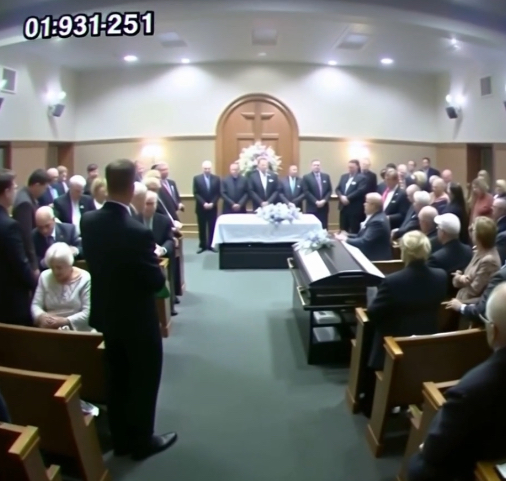 The funeral hall was silent, the only sound the soft sobs of grieving ...